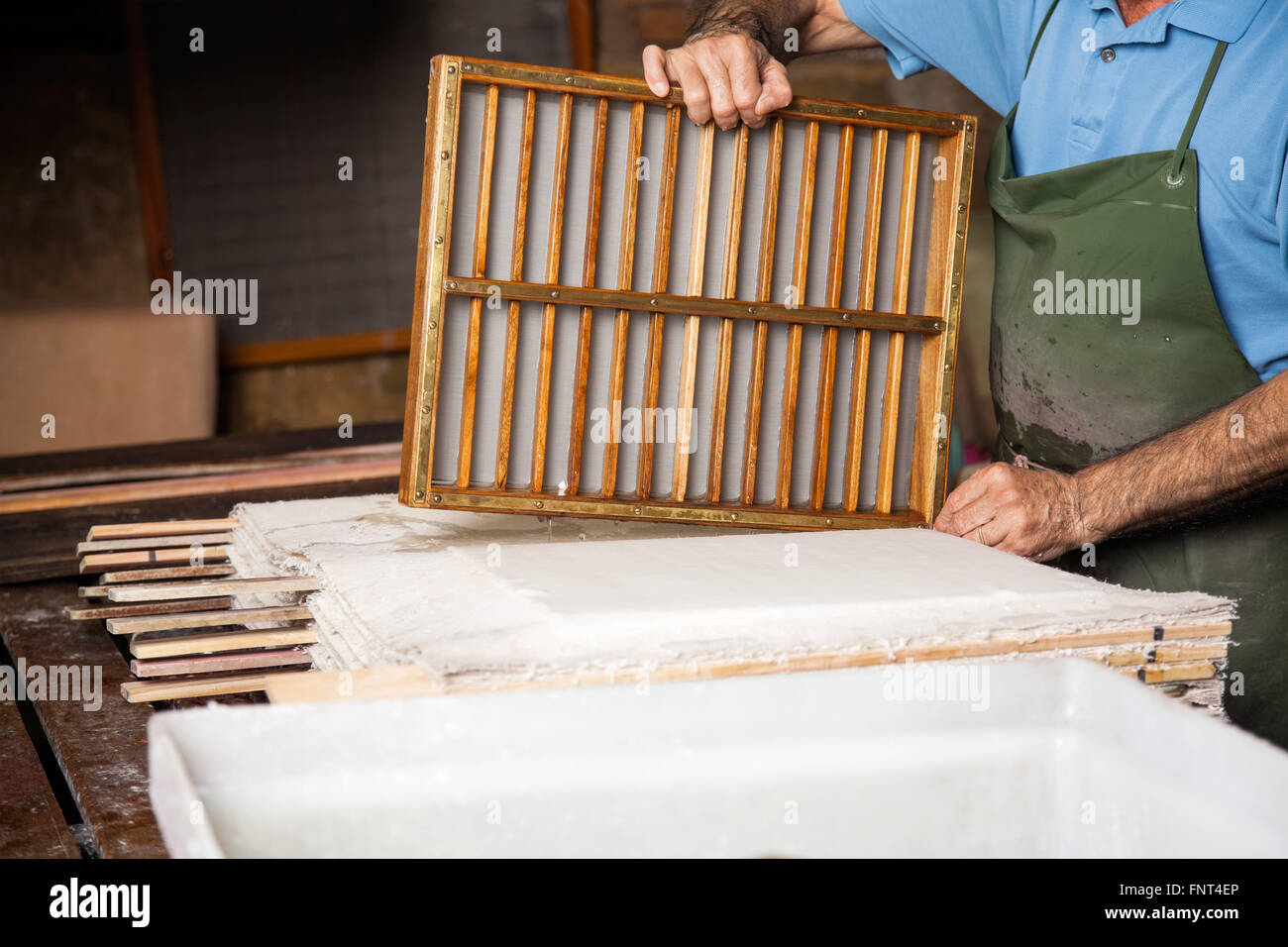Midsection of male worker holding mold on paper sheets in factory Stock ...