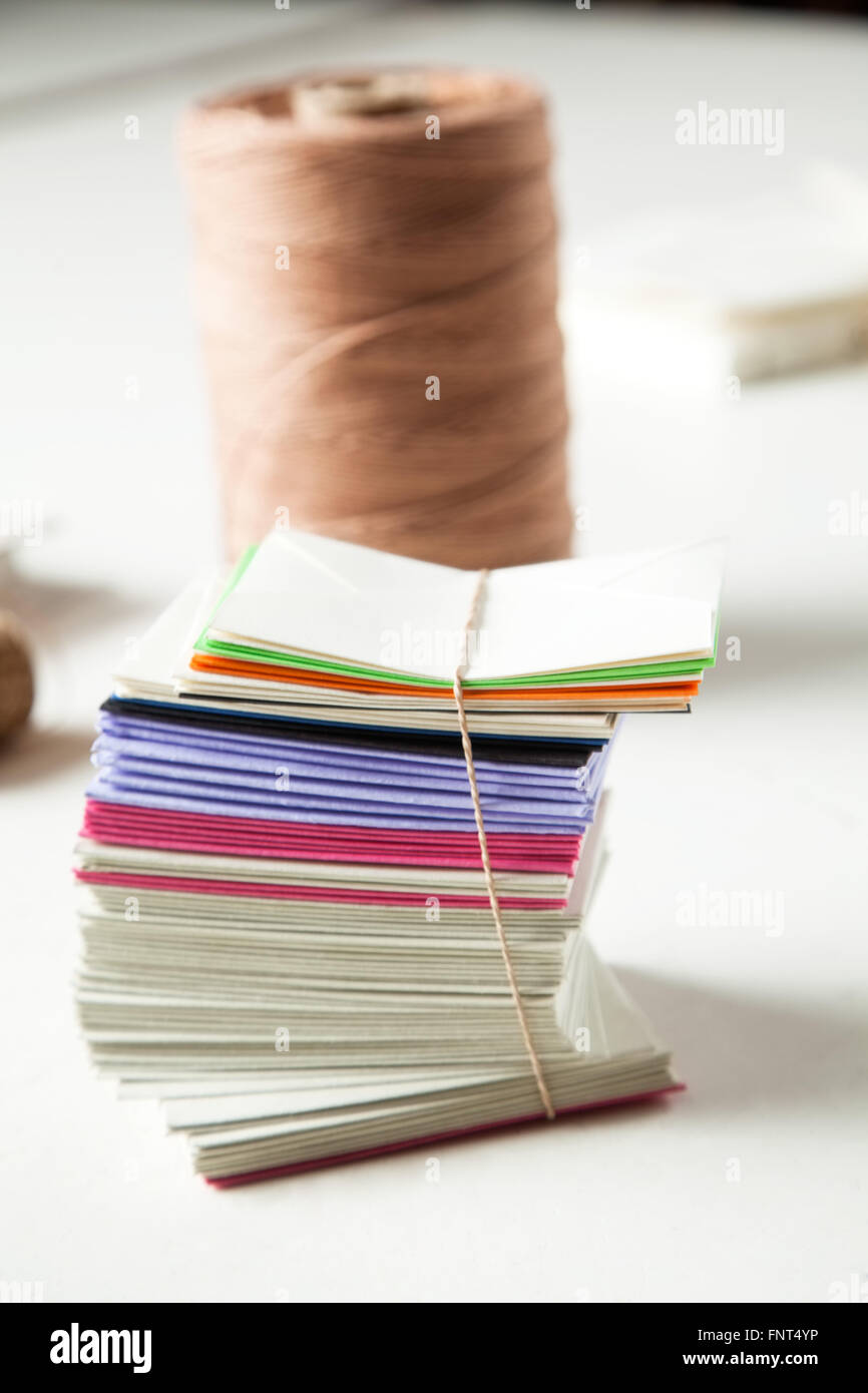 Closeup of stacked papers and thread on table in factory Stock Photo ...