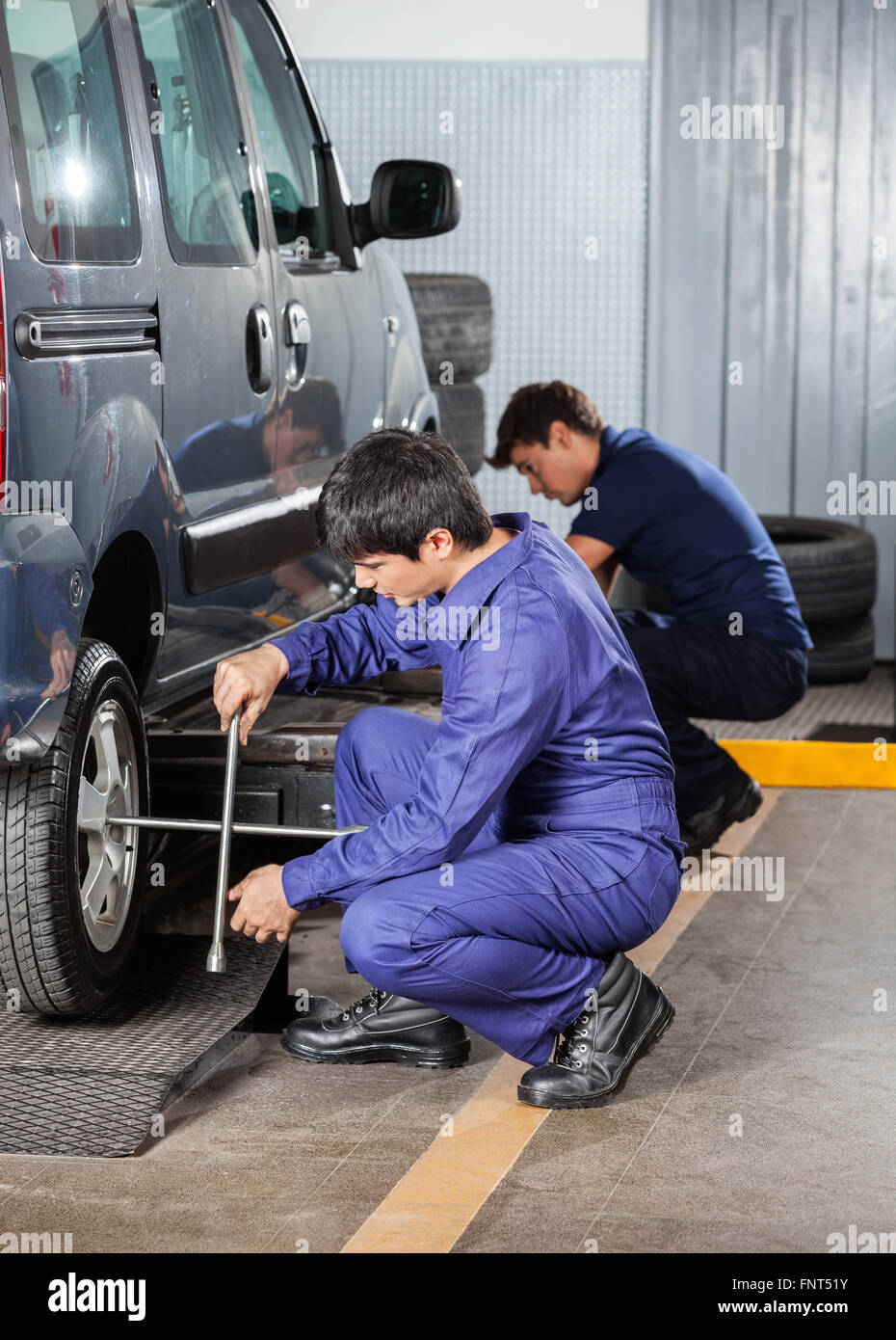 Male mechanics working together repairing hi-res stock photography and ...