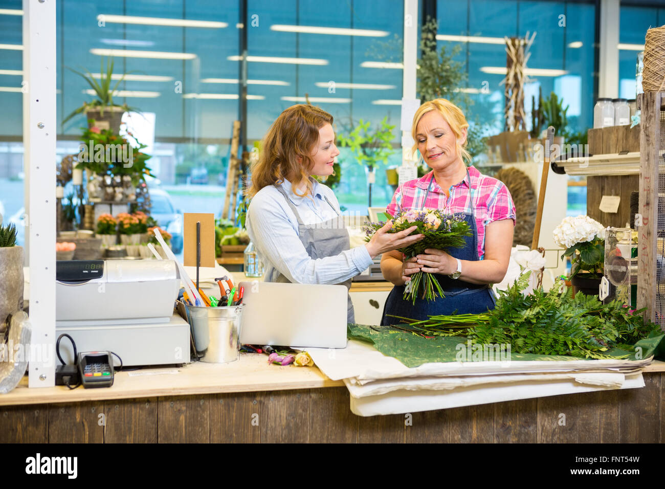 Florists making bouquet at counter in flower shop Stock Photo - Alamy