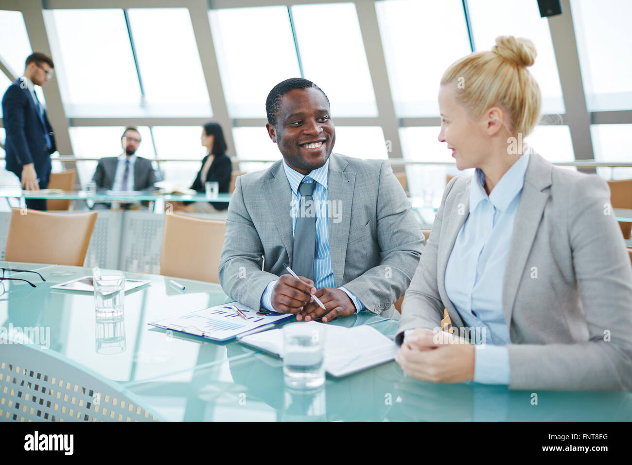 Business couple communicating at table during conference Stock Photo ...