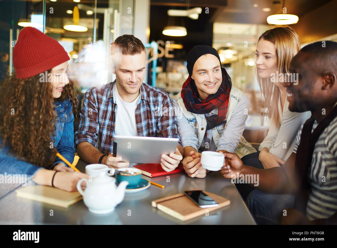 Group of students sitting at cafe and working together Stock Photo - Alamy
