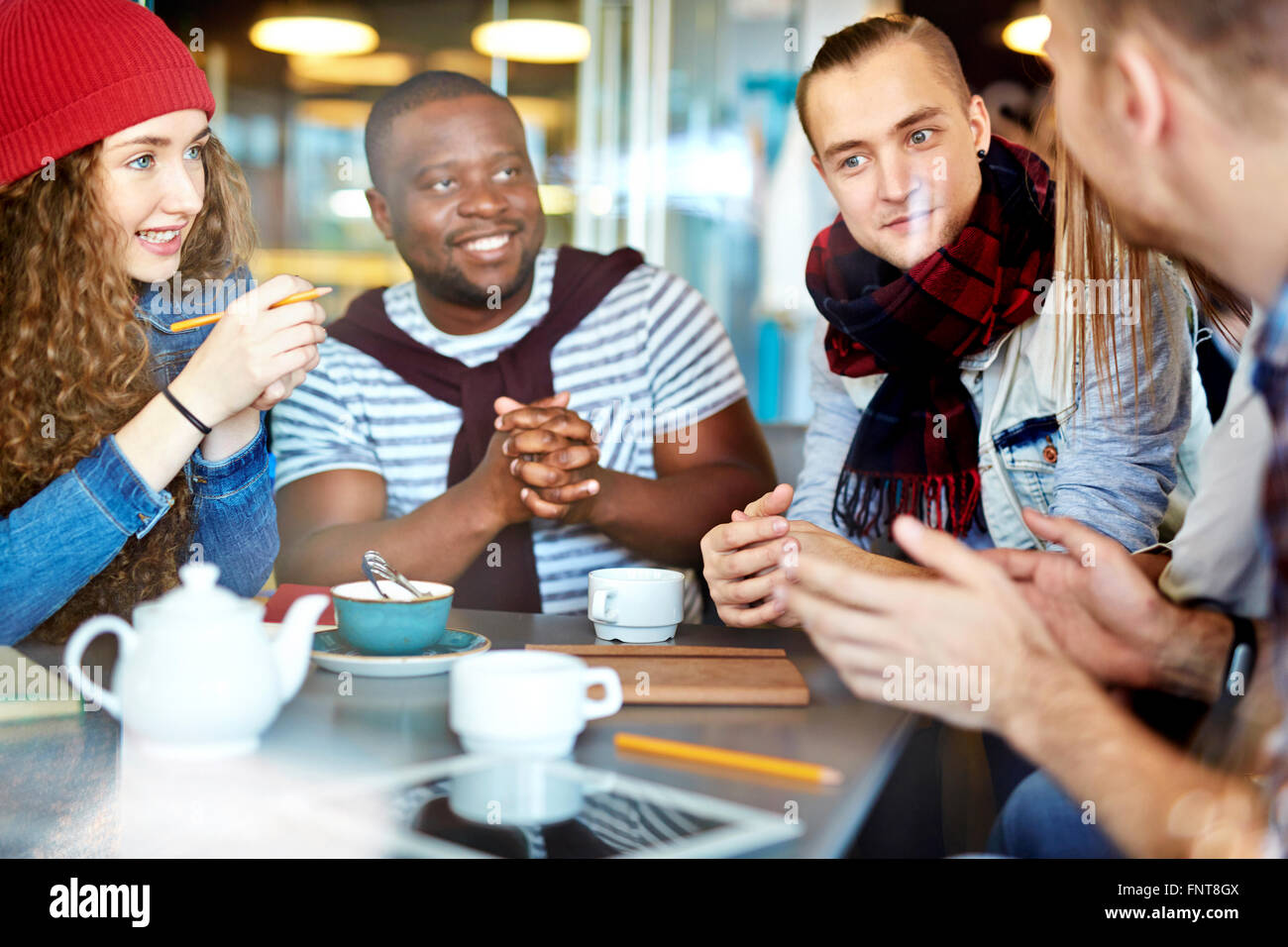 Group of friends discussing together at the table Stock Photo - Alamy