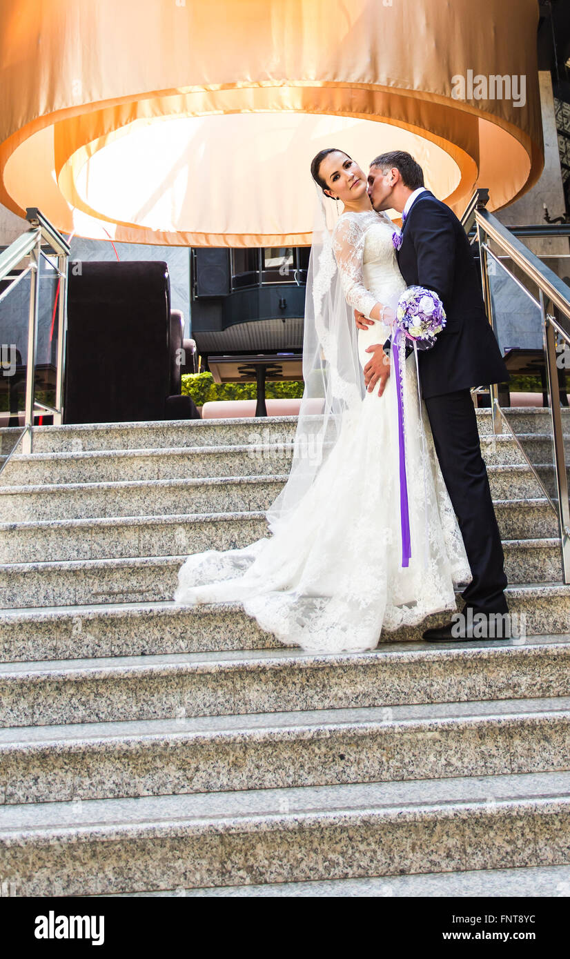 handsome groom kissing bride in neck Stock Photo - Alamy