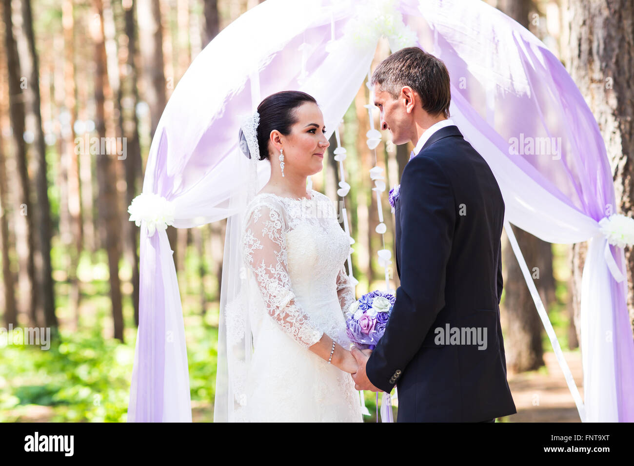 Bride and Groom Under wedding arch Stock Photo - Alamy