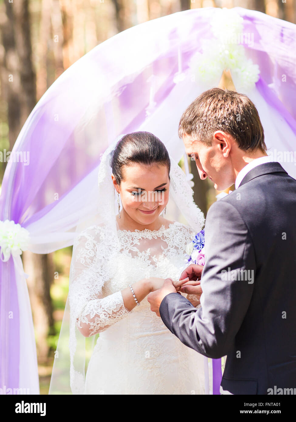 elegance groom putting on wedding ring his bride. Wedding ceremony ...