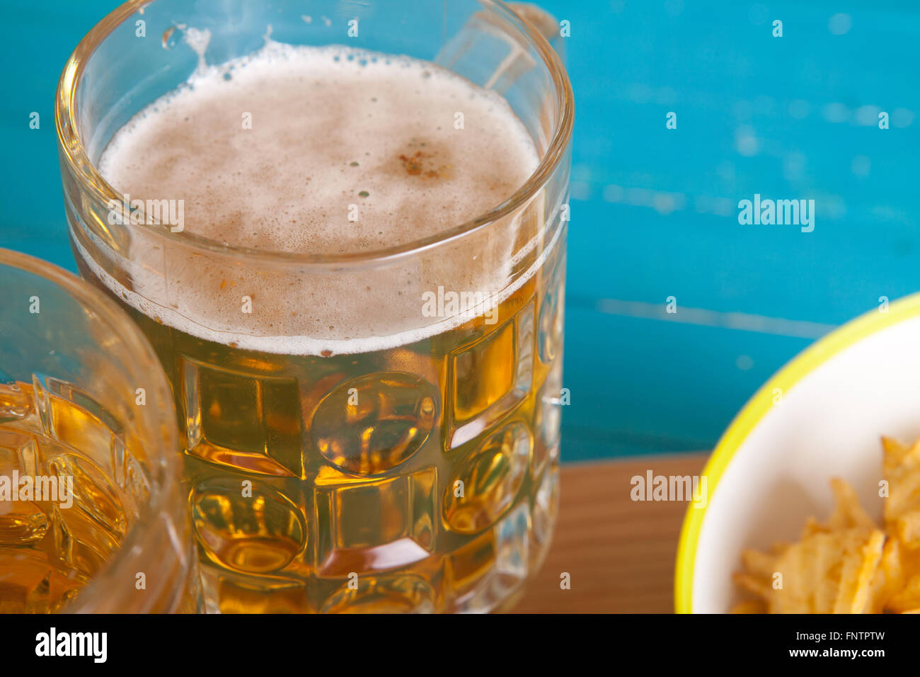 potato chips and two mugs of beer on the table Stock Photo - Alamy