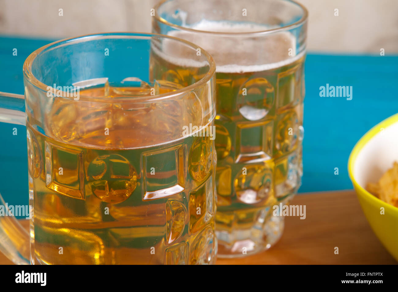 potato chips and two mugs of beer on the table Stock Photo - Alamy