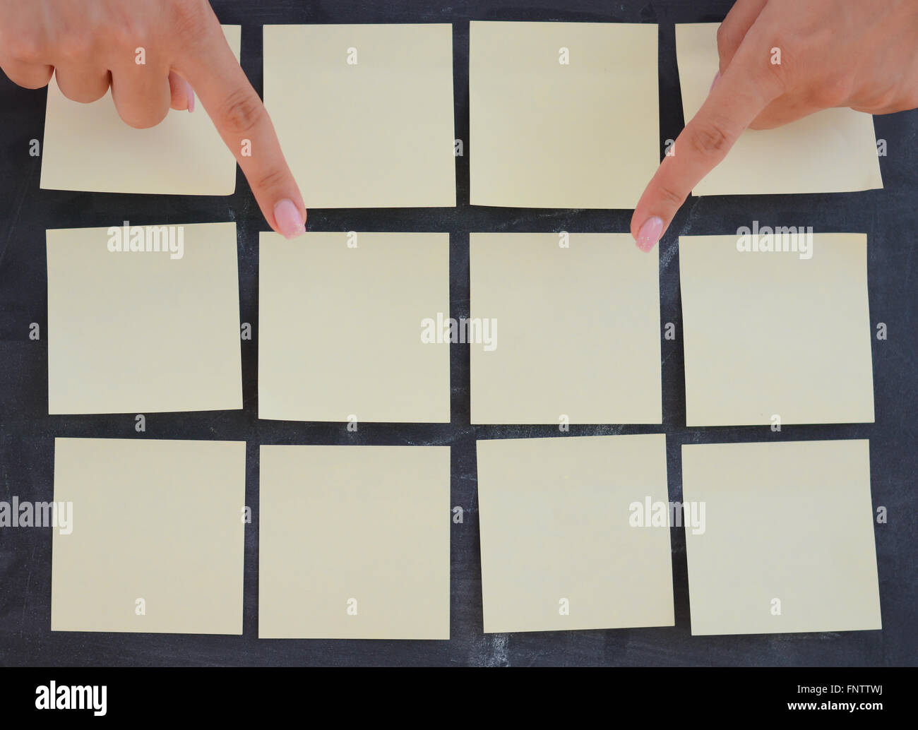 Woman hand posting empty adhesive notes on blackboard Stock Photo - Alamy