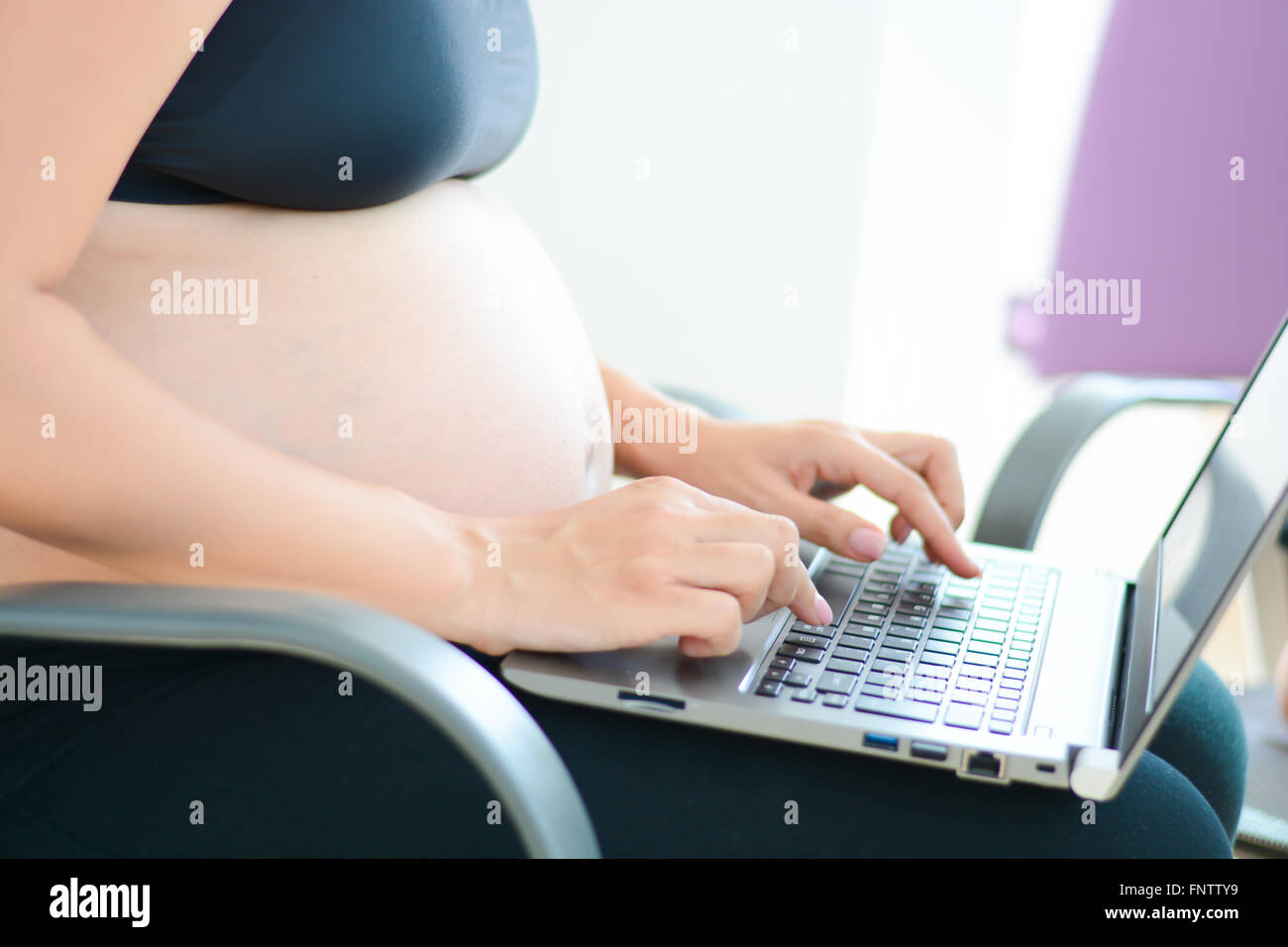 Young pregnant woman using a laptop computer at home Stock Photo - Alamy