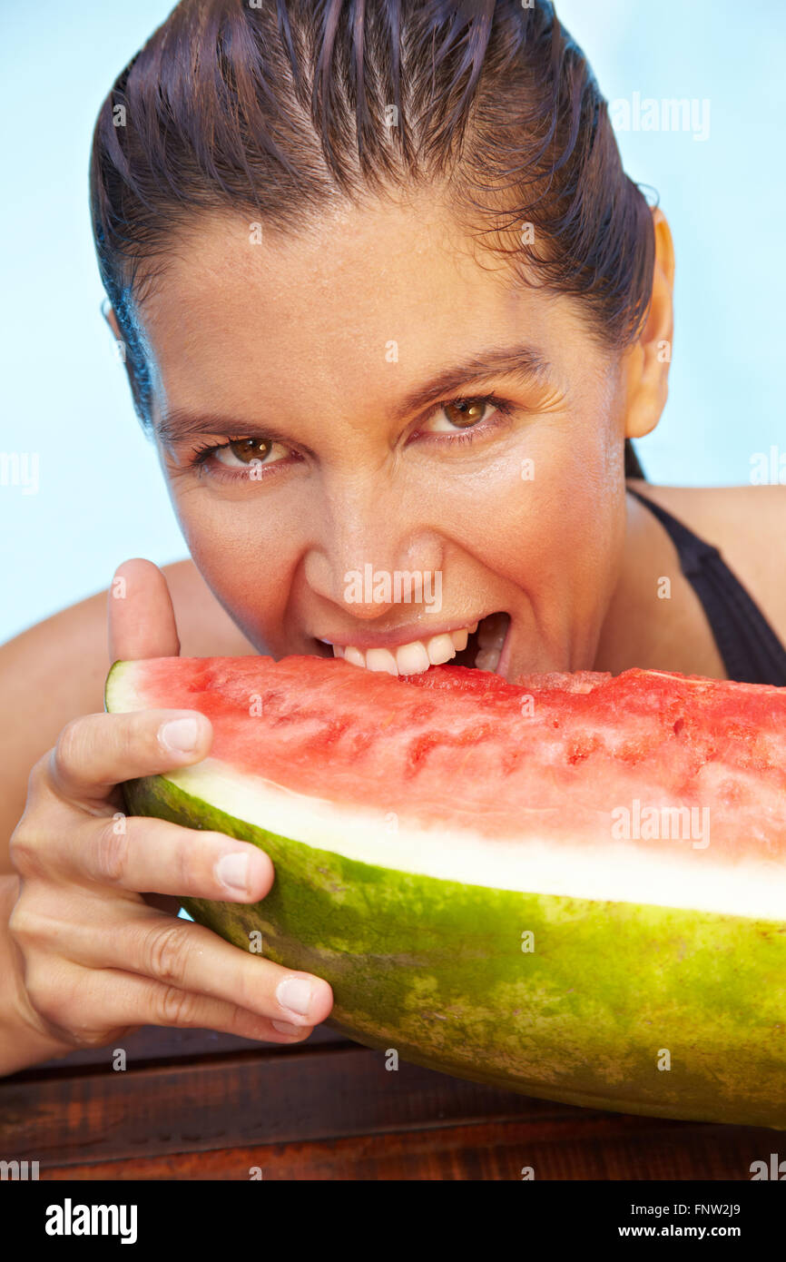 Brunette woman biting with teeth in a watermelon Stock Photo - Alamy