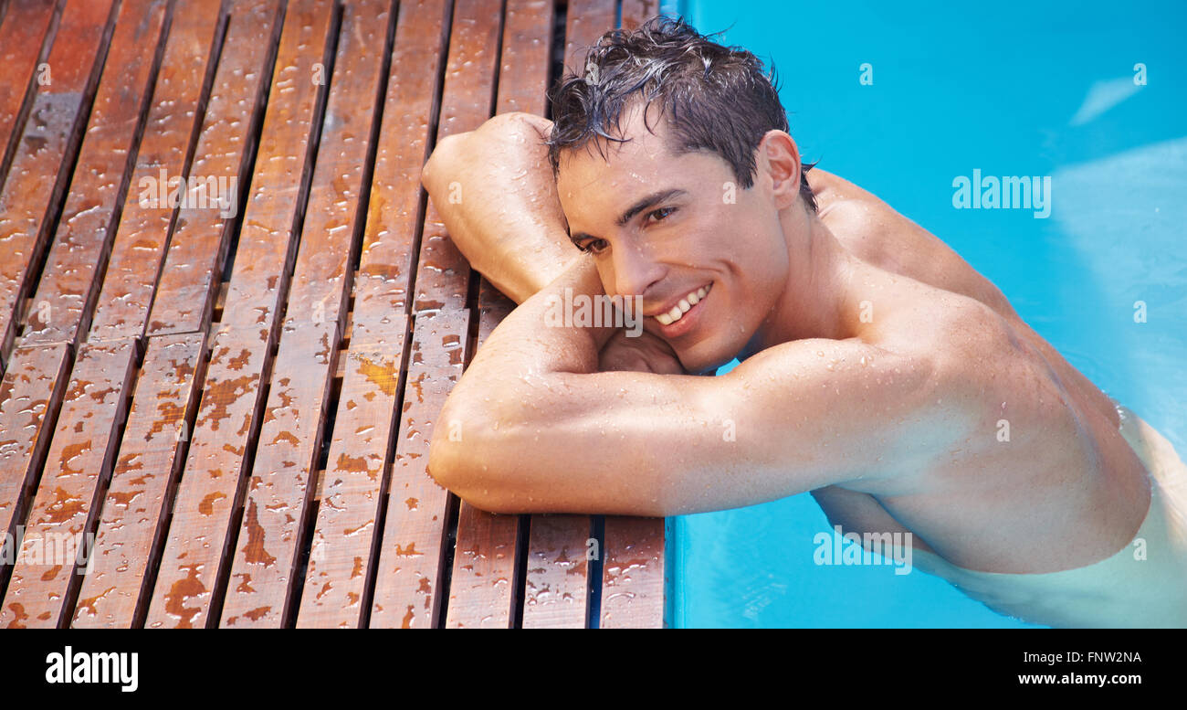 Happy attractive man resting relaxed on edge of swimming pool Stock ...