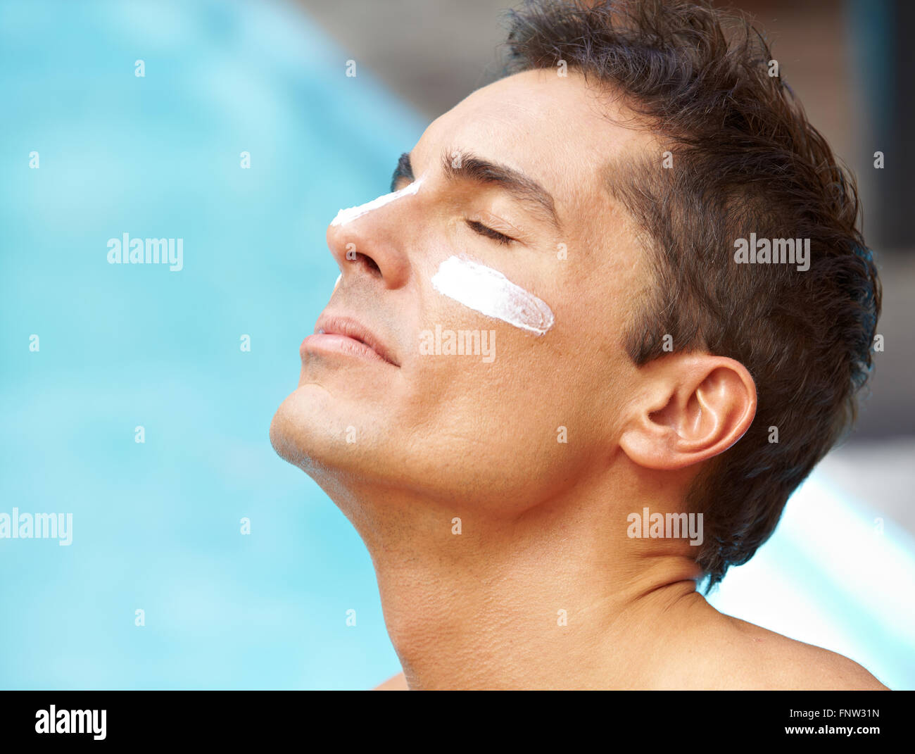 Attractive man sunbathing near pool with sunscreen on his face Stock ...