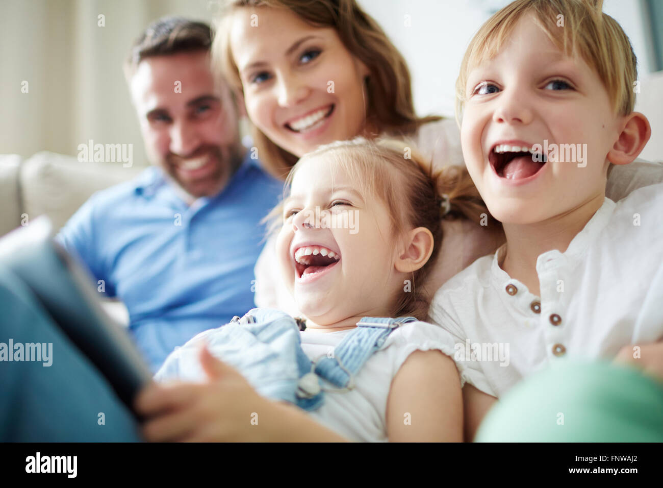 Children sitting together with parents and laughing Stock Photo - Alamy