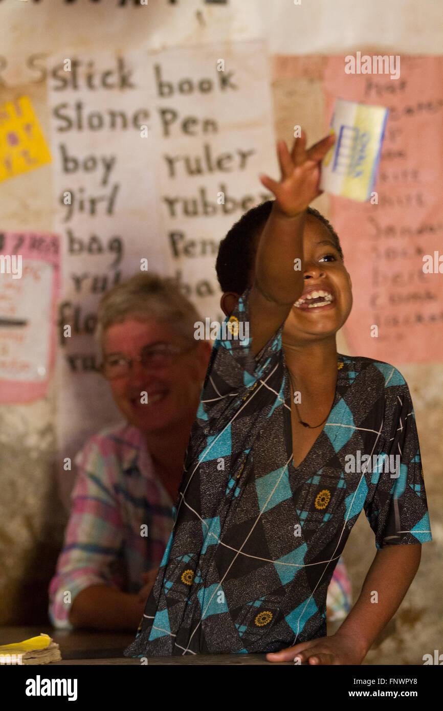 A child putting his hand up in the classroom to answer a question ...