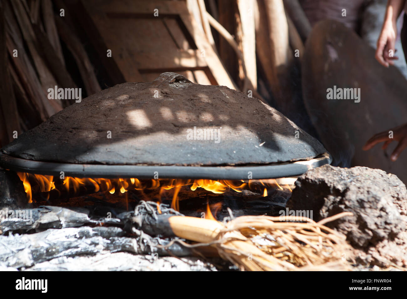 Making injera on an open fire. Injera is a large sourdough flatbread ...