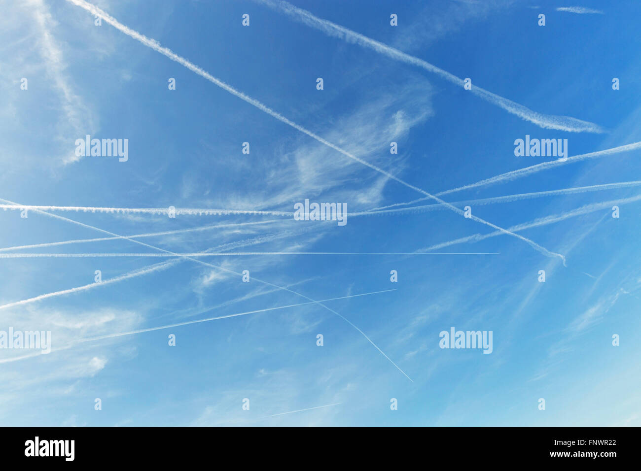 Airplane trails on blue sky Stock Photo - Alamy
