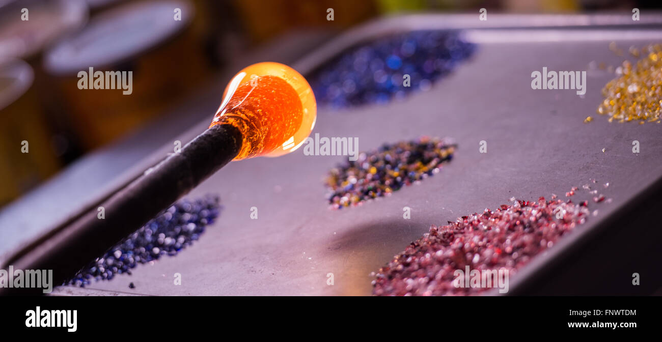 Glassblower adding color to hot glass Stock Photo - Alamy