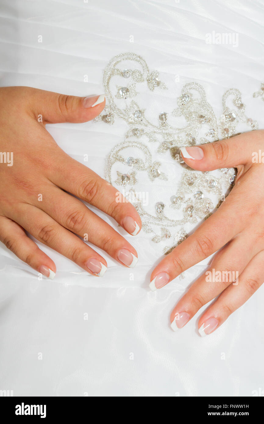 Hands of the bride on a white wedding dress Stock Photo - Alamy