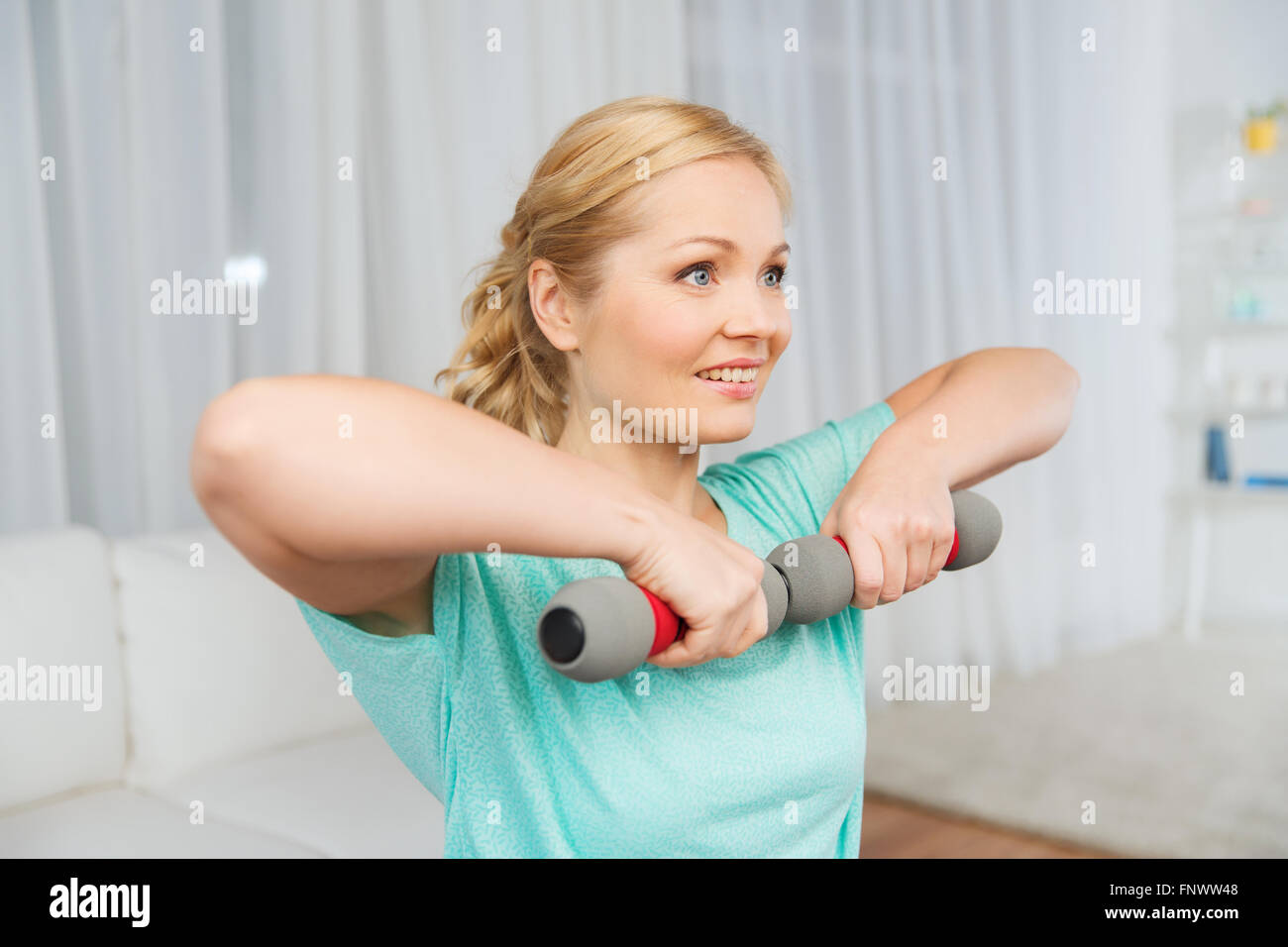 woman exercising with dumbbells on mat at home Stock Photo - Alamy