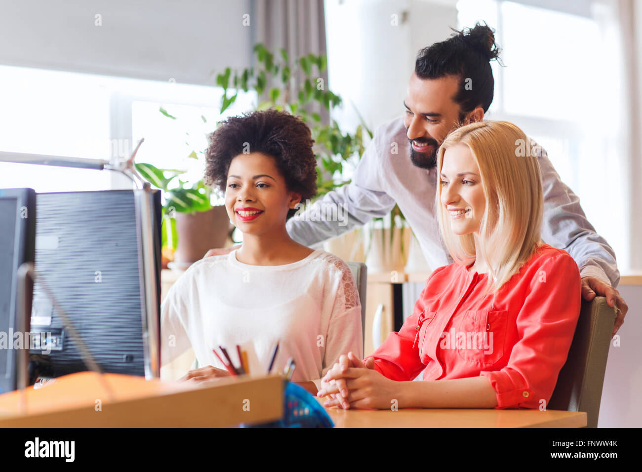 happy creative team with computer in office Stock Photo - Alamy
