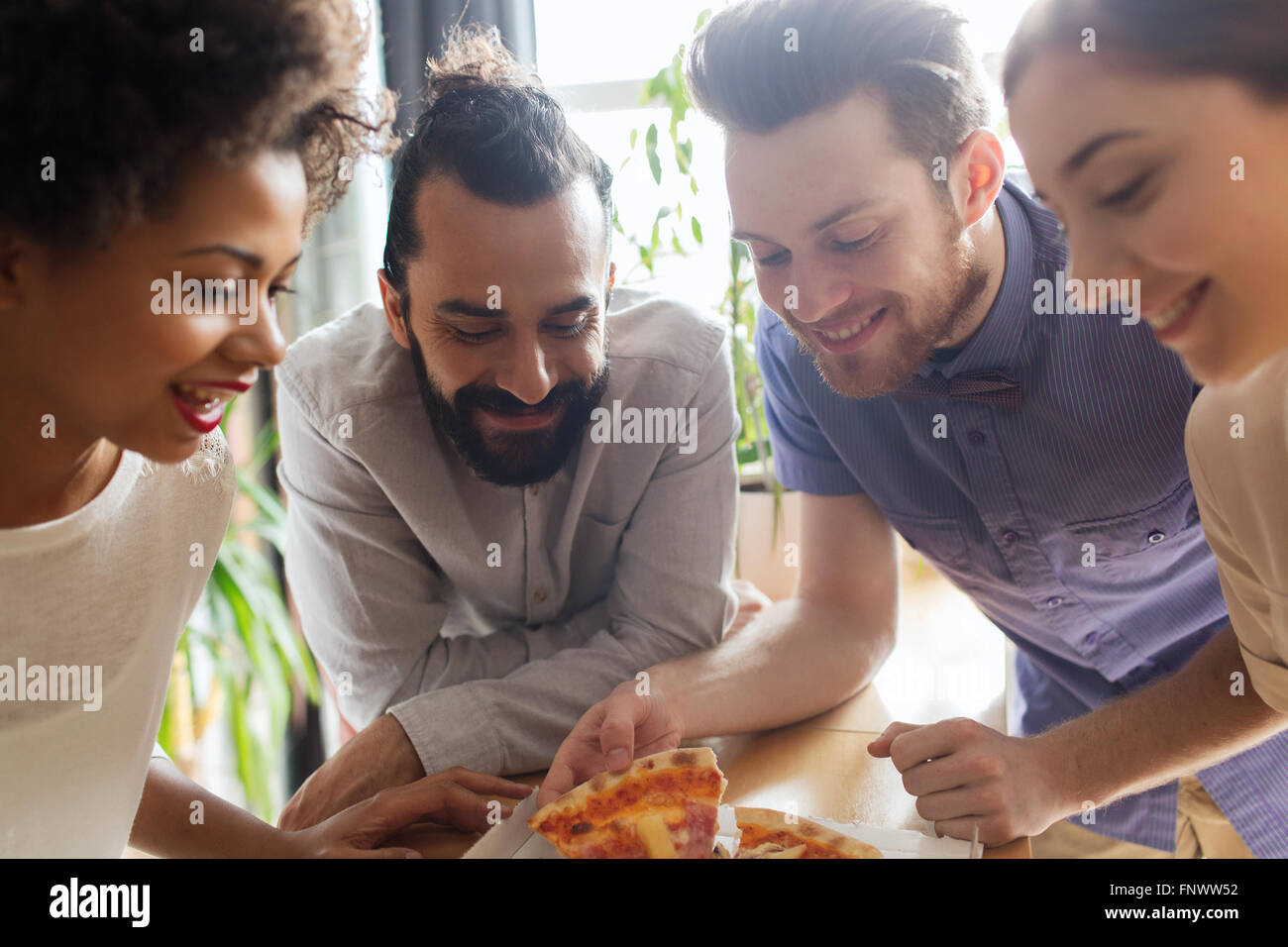 happy business team eating pizza in office Stock Photo - Alamy