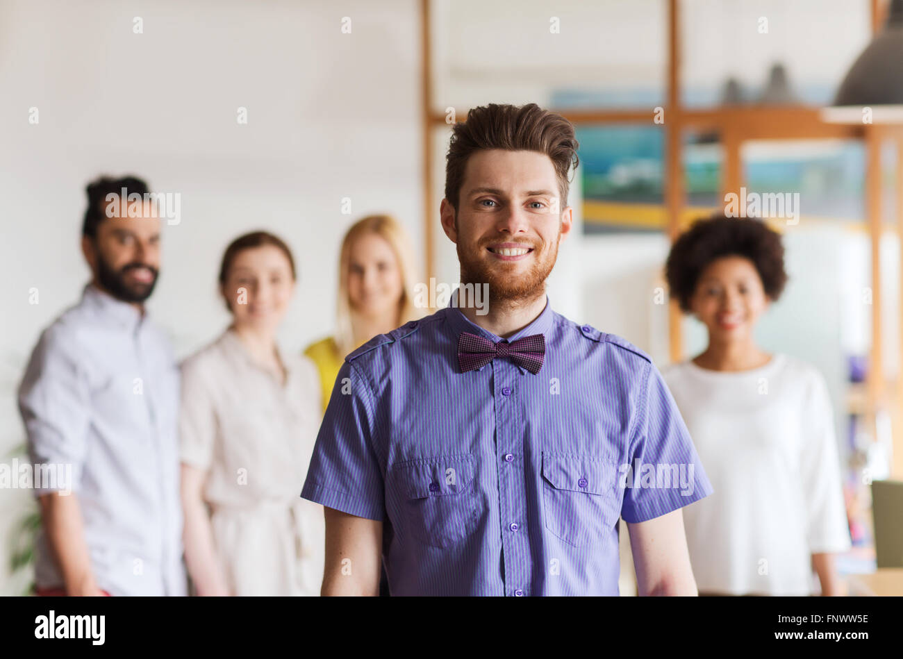 happy young man over creative team in office Stock Photo - Alamy