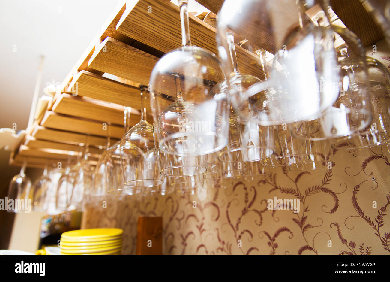 wine glasses hanging upside down on bar holder Stock Photo - Alamy