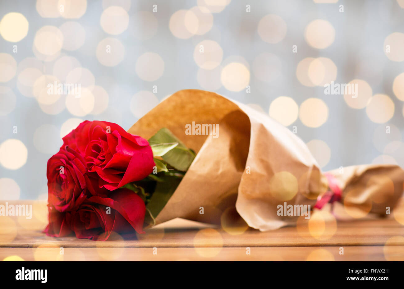 close up of red roses bunch wrapped into paper Stock Photo - Alamy