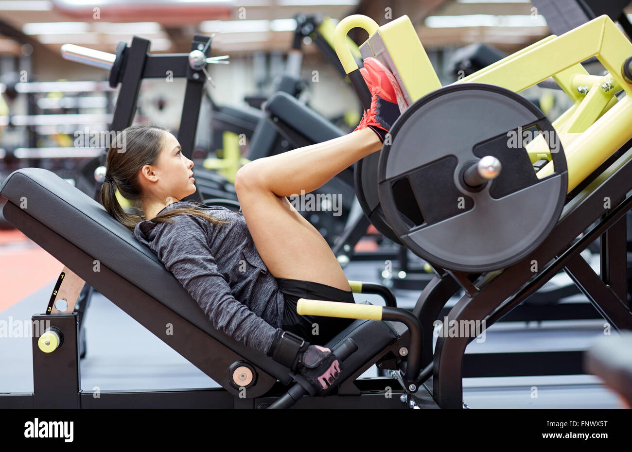woman flexing muscles on leg press machine in gym Stock Photo - Alamy
