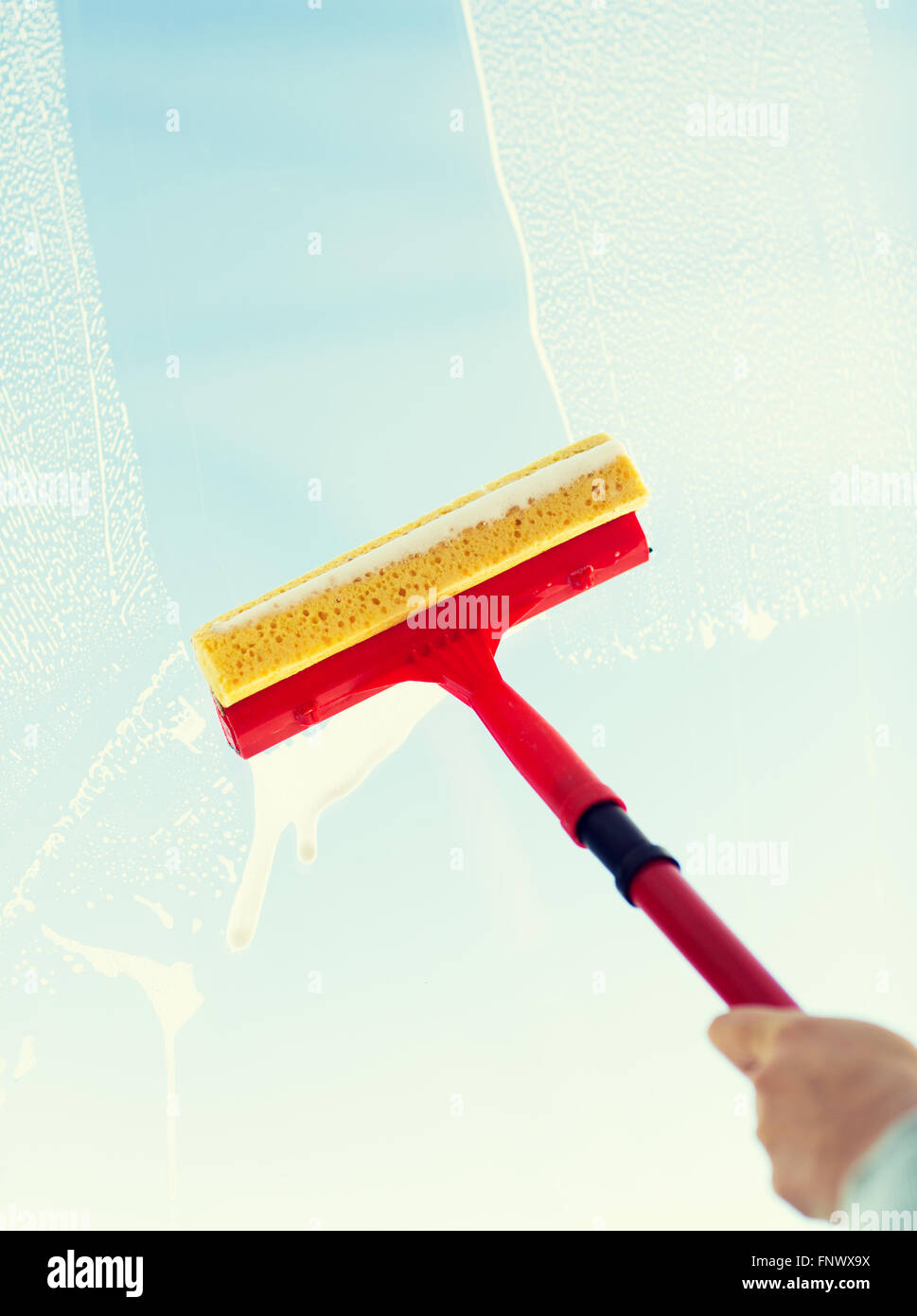 close up of hand cleaning window with sponge Stock Photo - Alamy