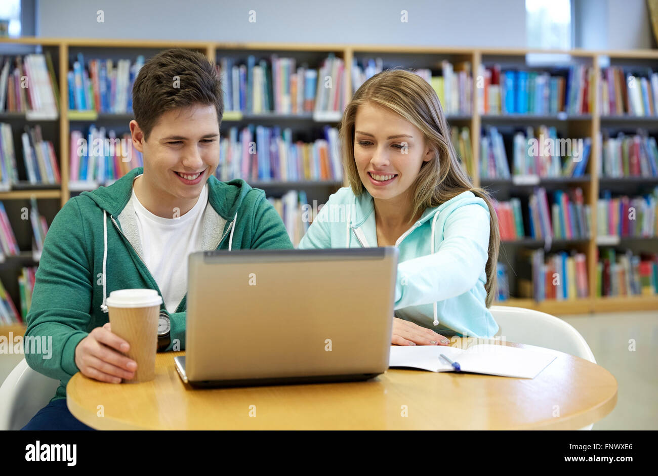 happy students with laptop in library Stock Photo - Alamy