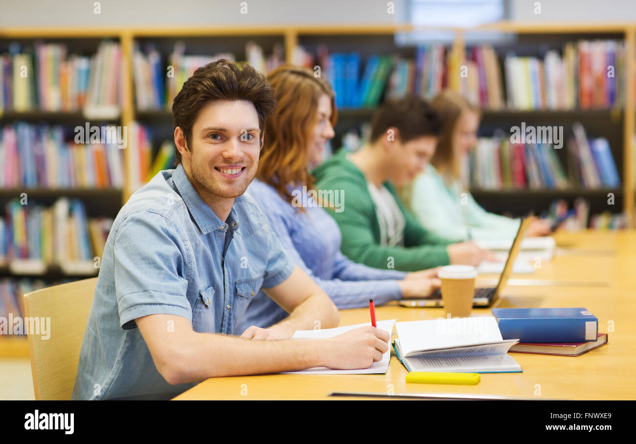 happy student boy with books writing in library Stock Photo - Alamy