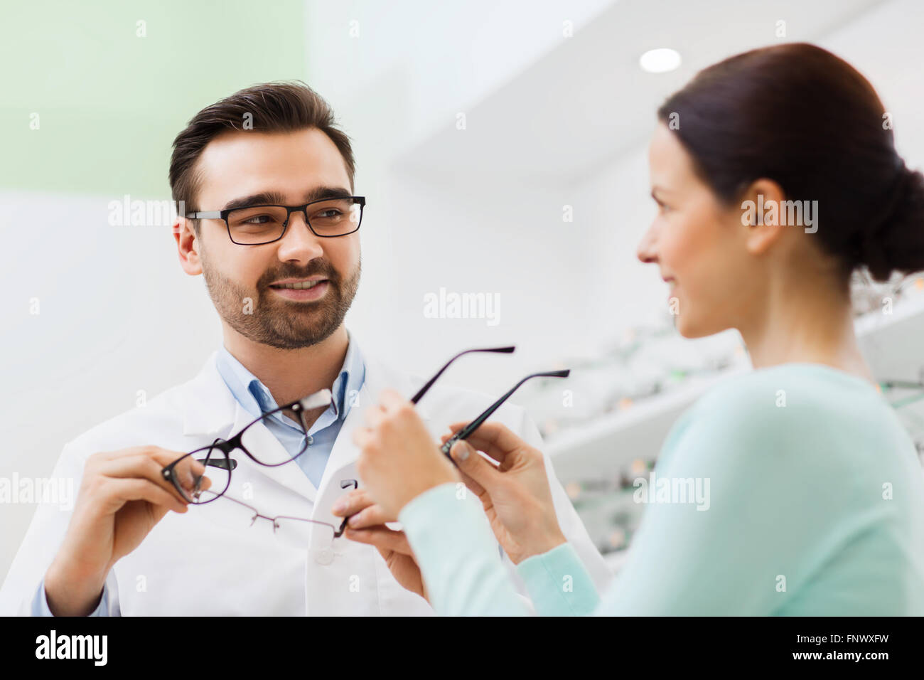 woman and optician showing glasses at optics store Stock Photo - Alamy