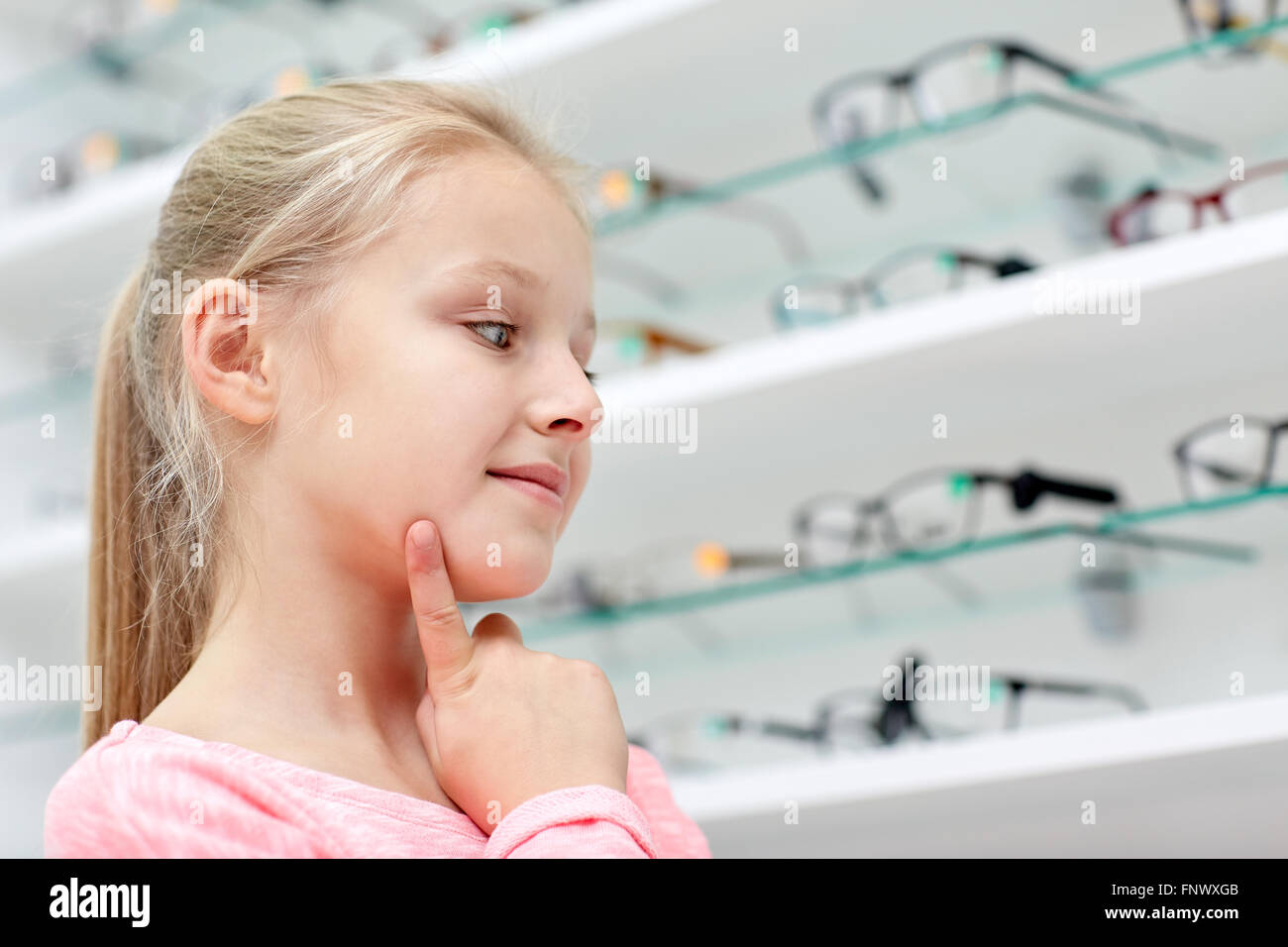 little girl choosing glasses at optics store Stock Photo - Alamy