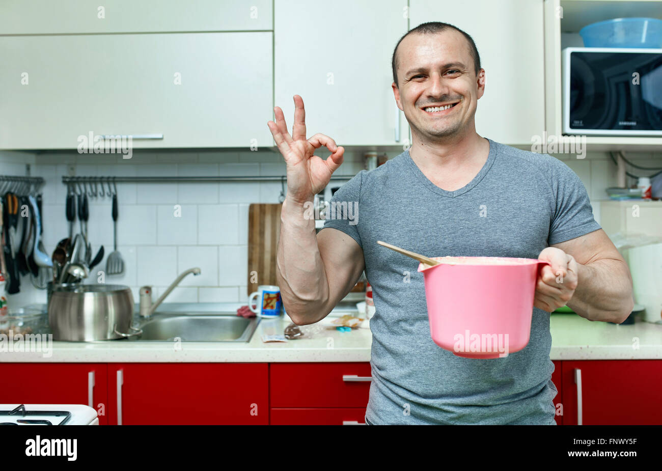 Man cooking alone at home making ok sign Stock Photo - Alamy