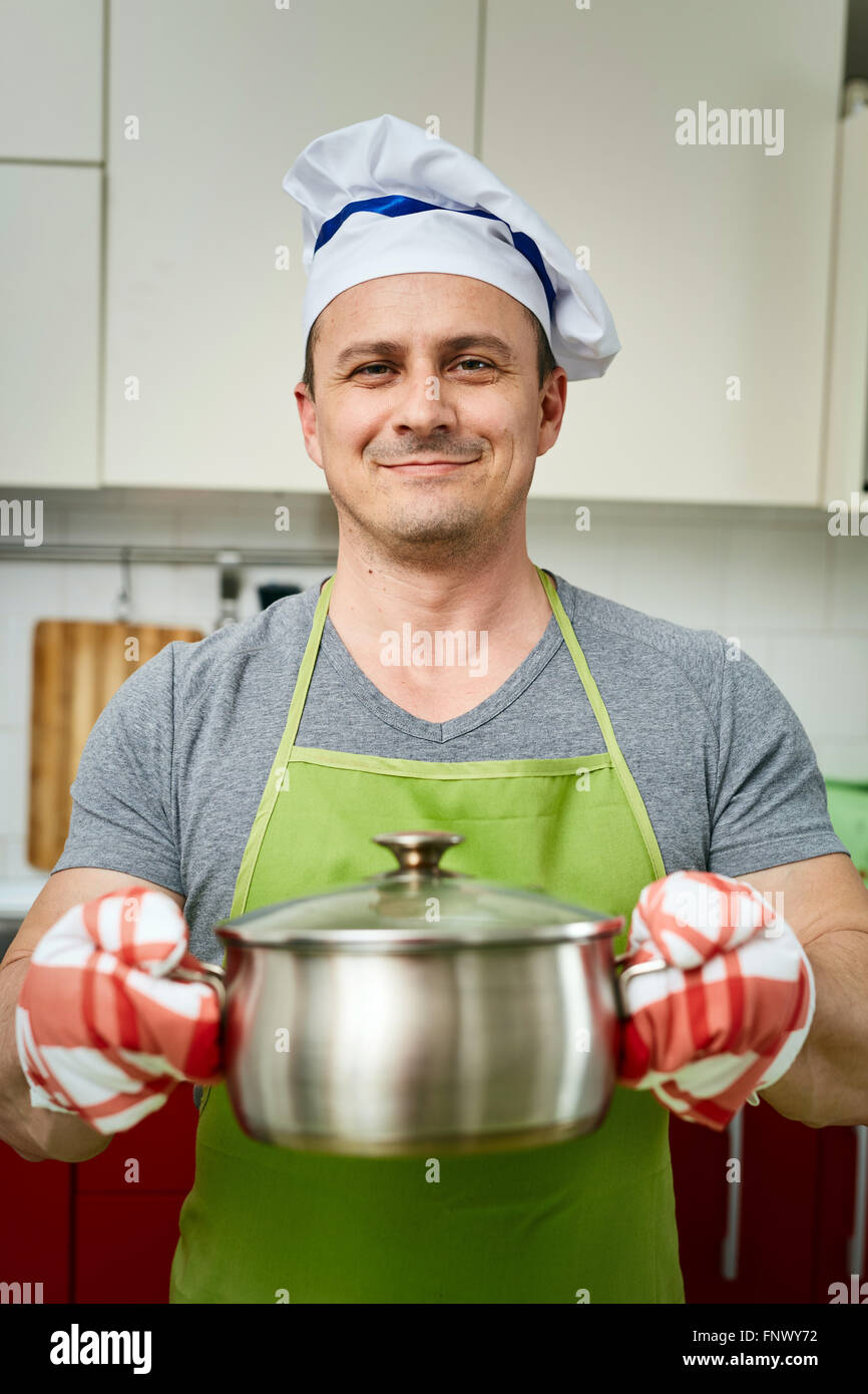 Handsome cook holding a stainless steel pot with lid on Stock Photo - Alamy