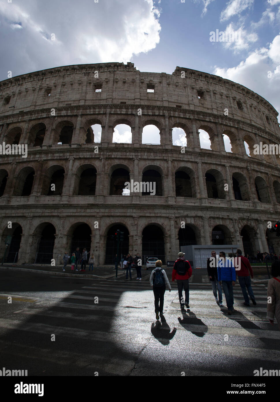 The Colosseum Rome, Italy. Tourists walk through sunlight on their way ...