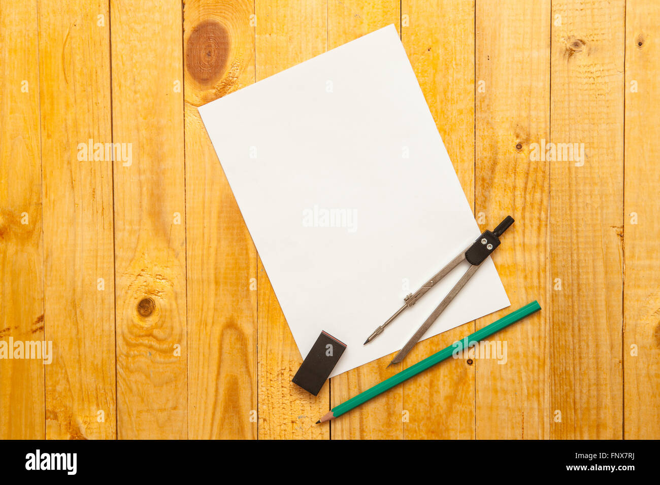 sheet of paper with compass pencil and eraser on a wooden backgr Stock ...