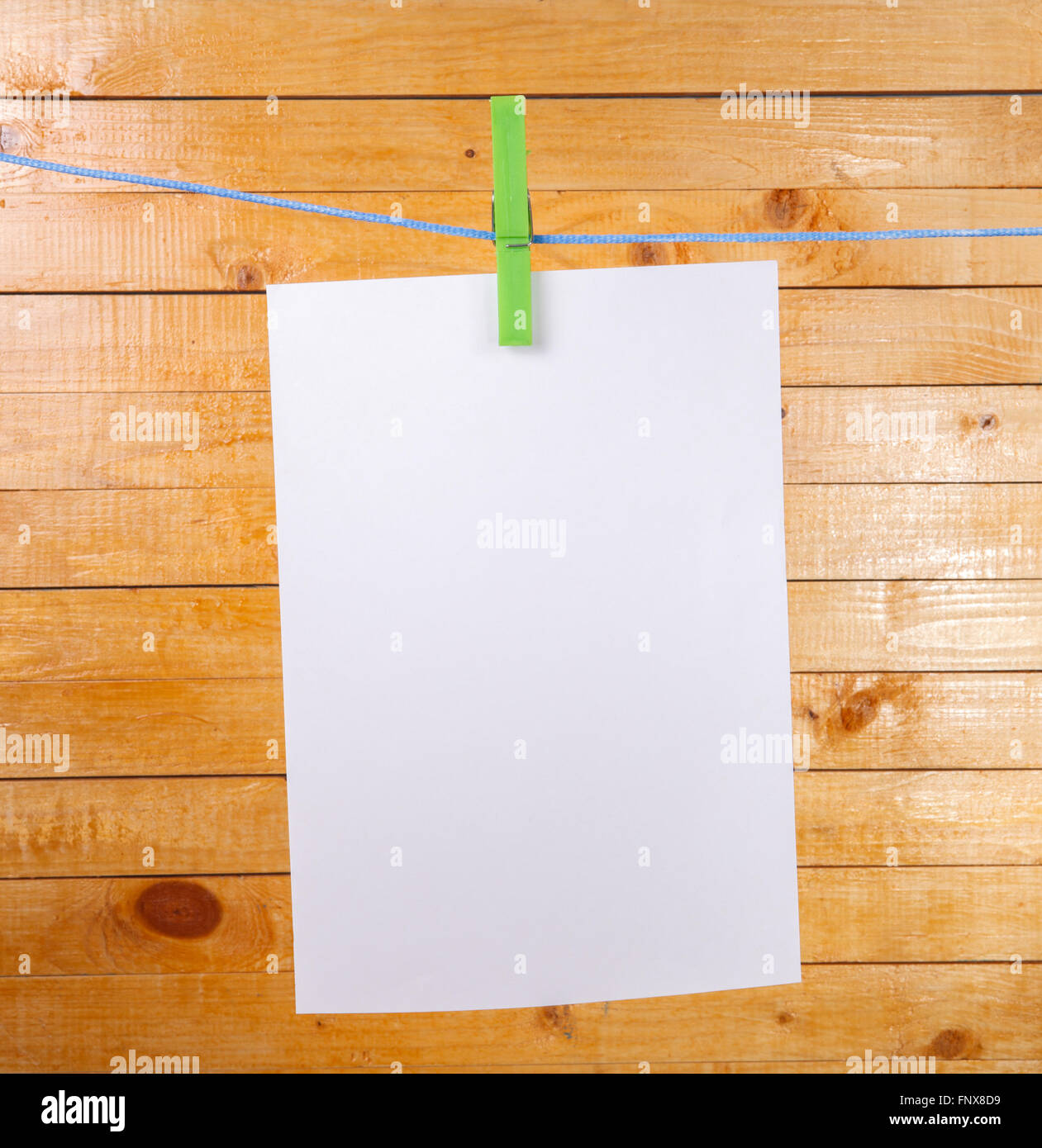 sheet of white paper hanging on clothespins on plank background Stock ...