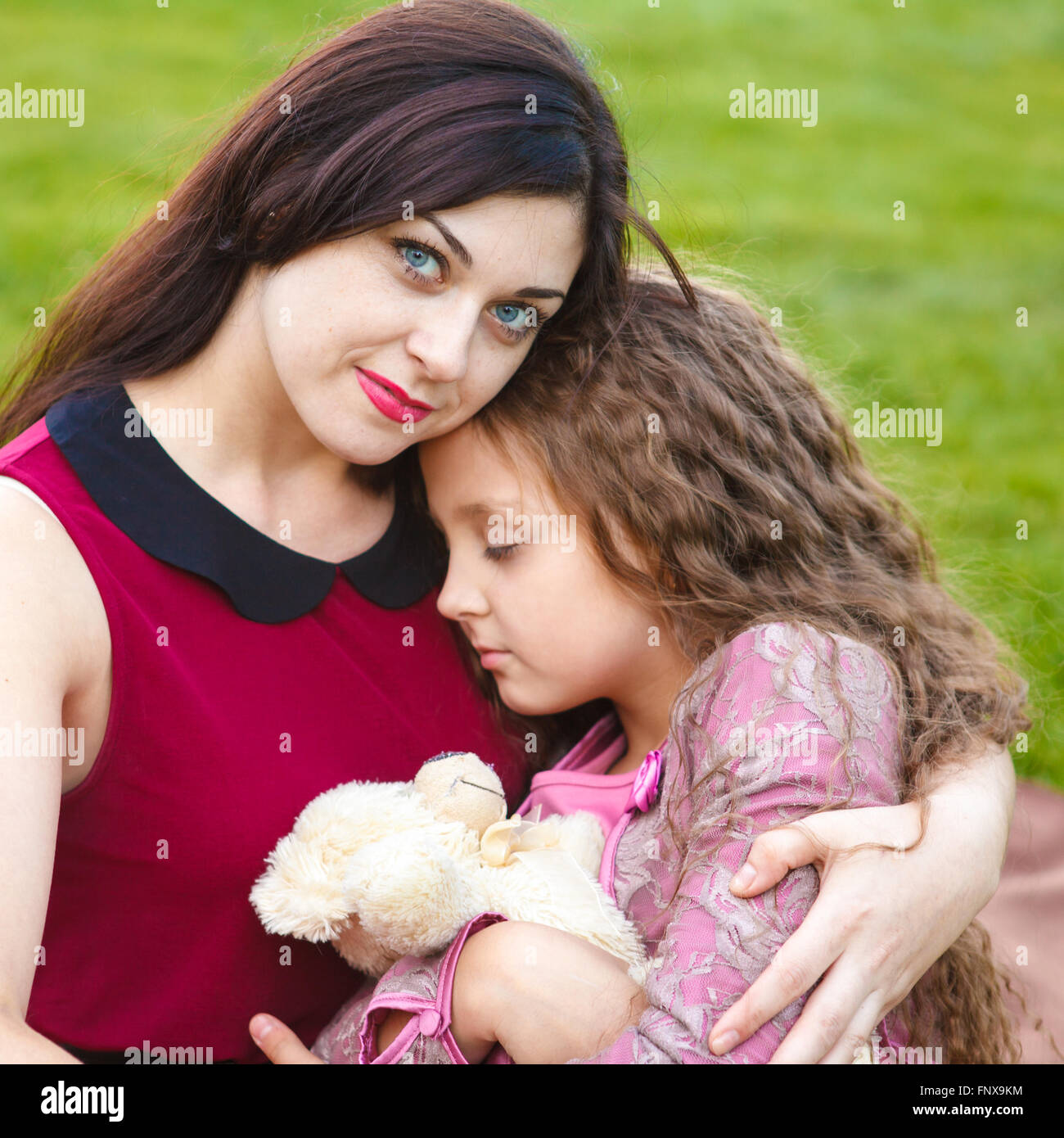 Mother hugs daughter in the park Stock Photo - Alamy