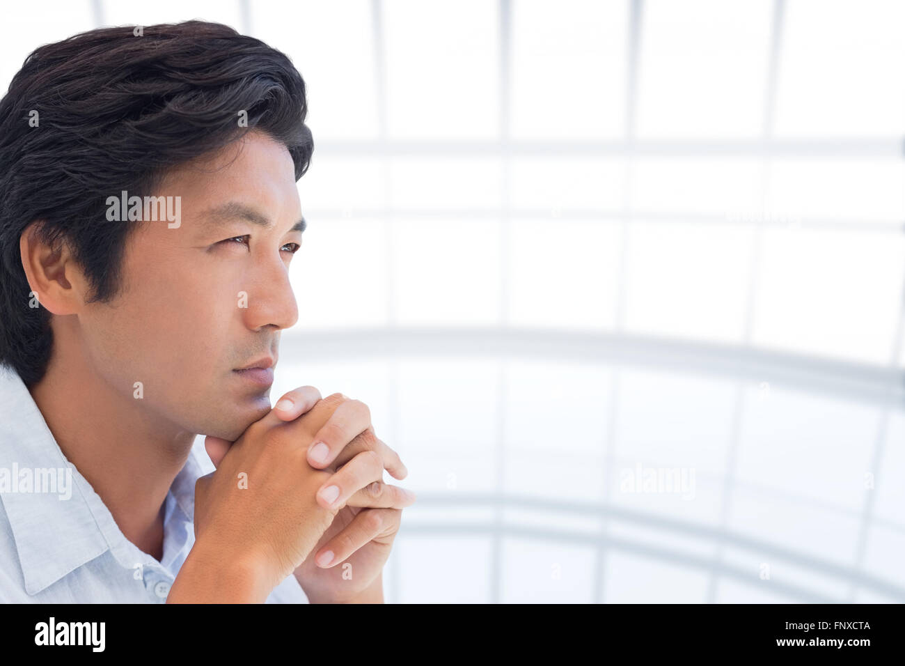 Composite image of thinking man with hands together Stock Photo - Alamy