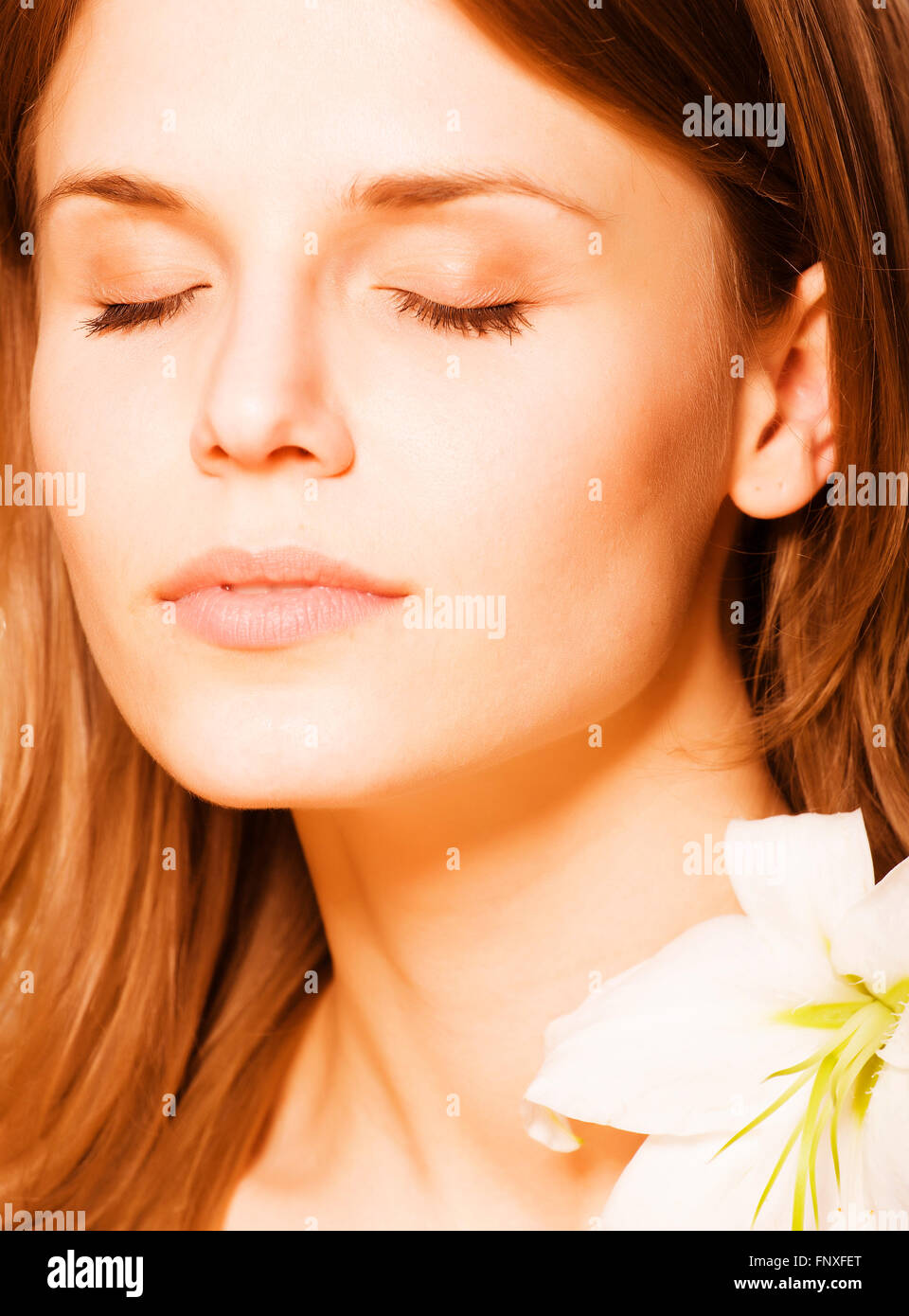 young attractive lady close up with hands on face isolated flower lily ...