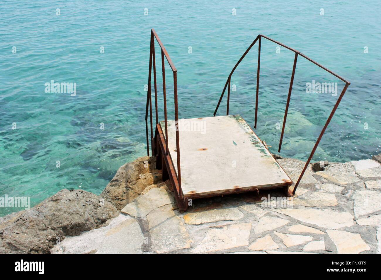 rusty steps of stairs into ocean sea on greek island Stock Photo - Alamy
