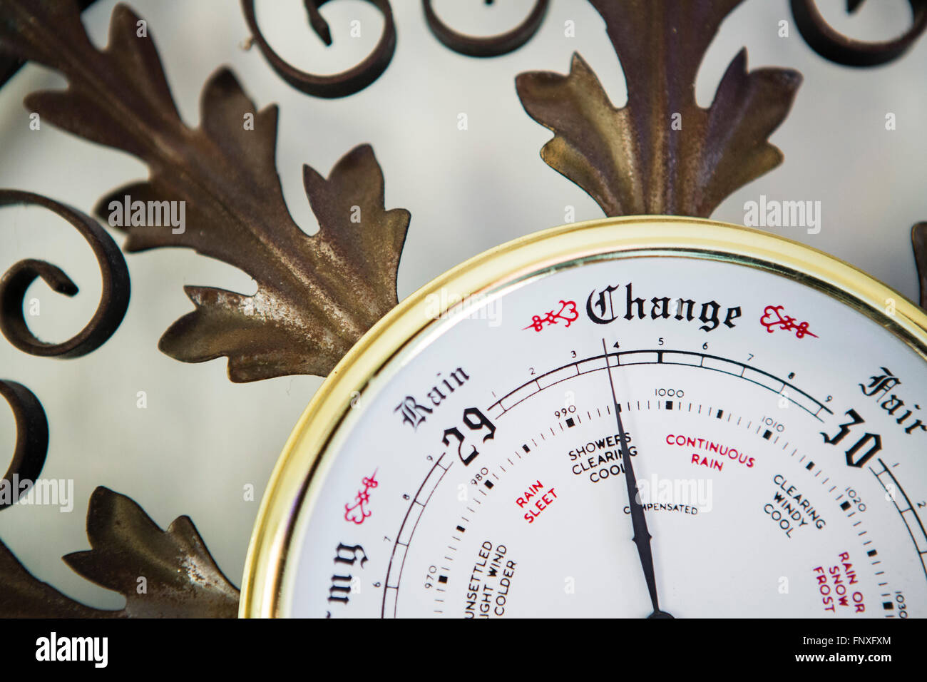 An old barometer on the wall indicating chnage with its arrow pointer ...