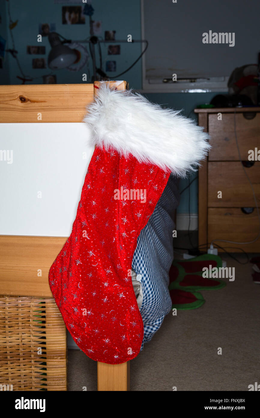 Decorative christmas stocking hanging against a bed with tinsel fairy ...