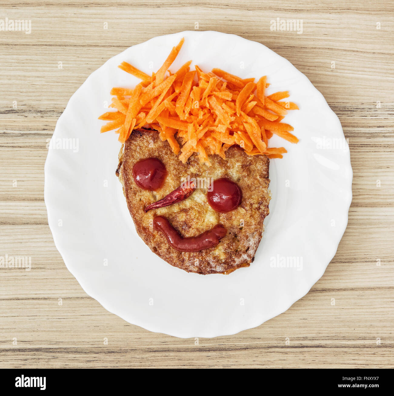 Funny face made of bread, carrot, chilli, tomatoes and ketchup ...
