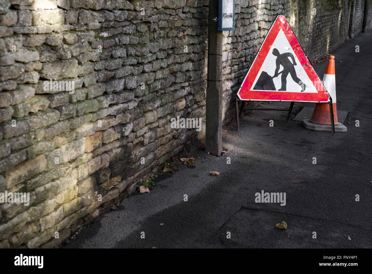 Work mens warning triangle on a pathway Stock Photo - Alamy