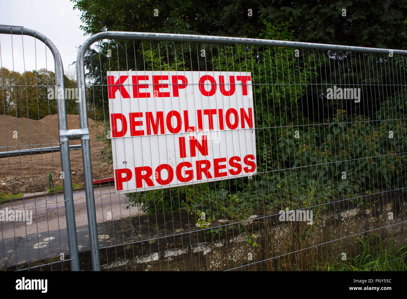 A red painted warning sign on a fence outside a demolition site Stock ...