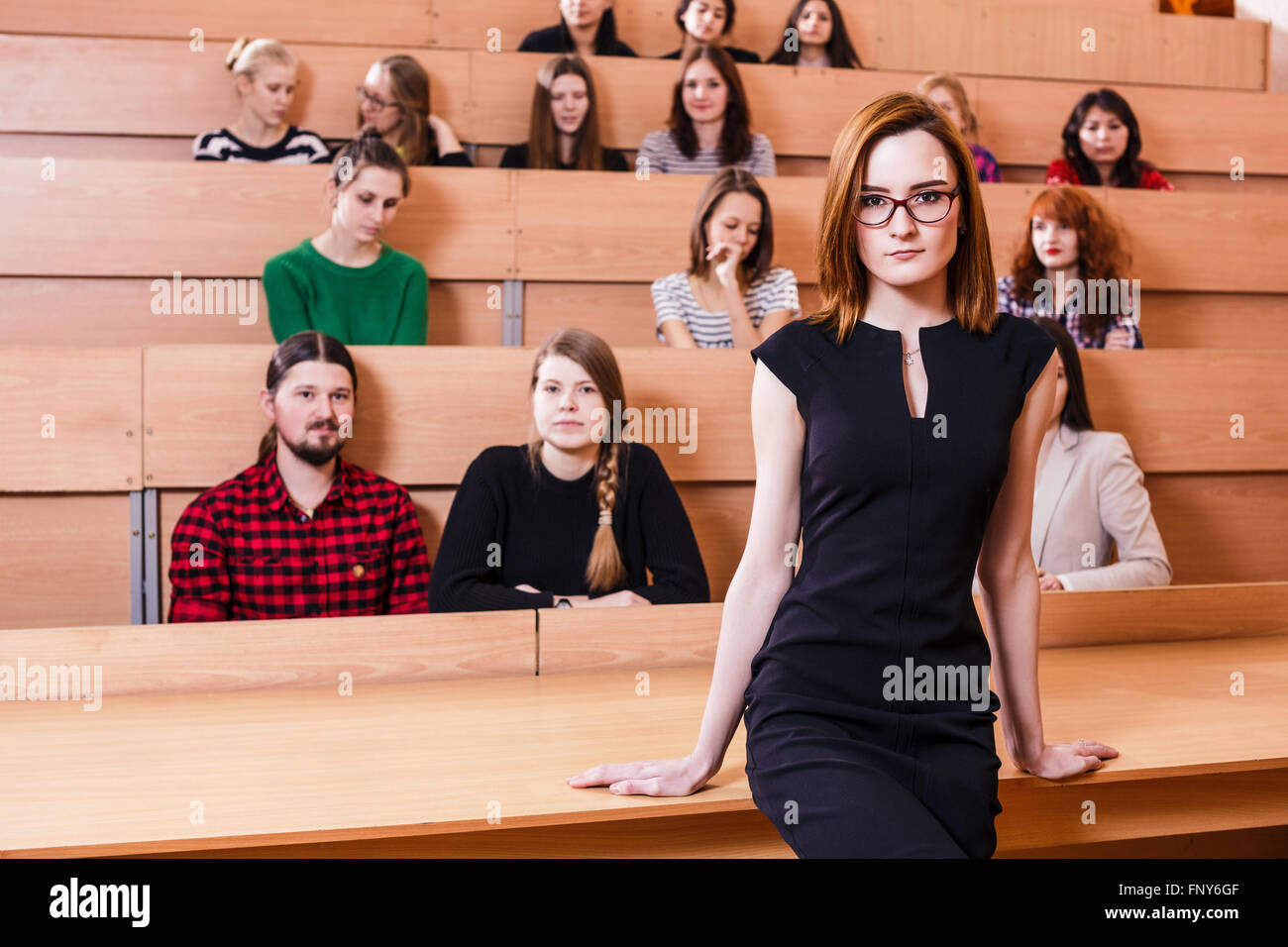 Teacher explaining something to students in classroom Stock Photo - Alamy